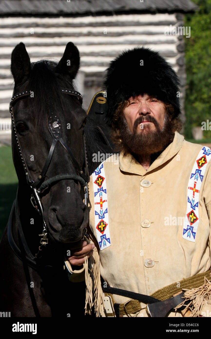 A Russian Cossack posing with his horse in front of a log cabin Stock ...