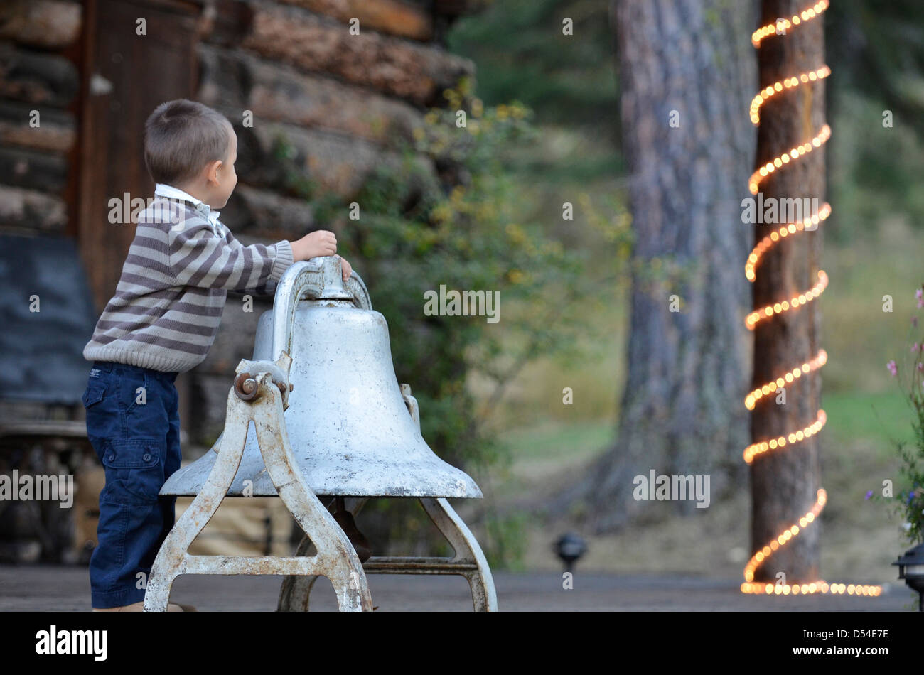 Young boy trying to ring a large bell Stock Photo - Alamy