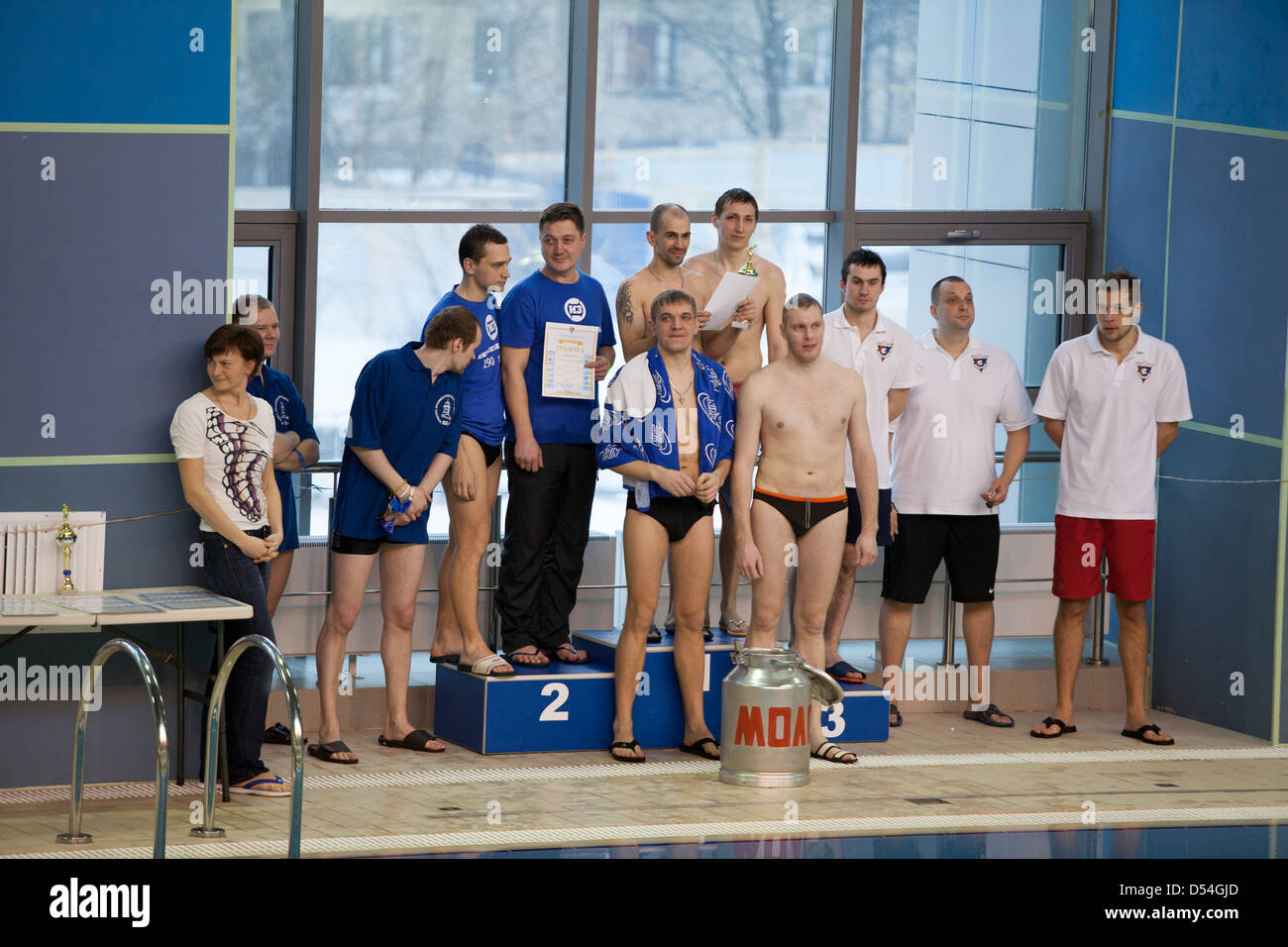 Swimmers on the podium during the awarding a relay swim. Swimming pool ...