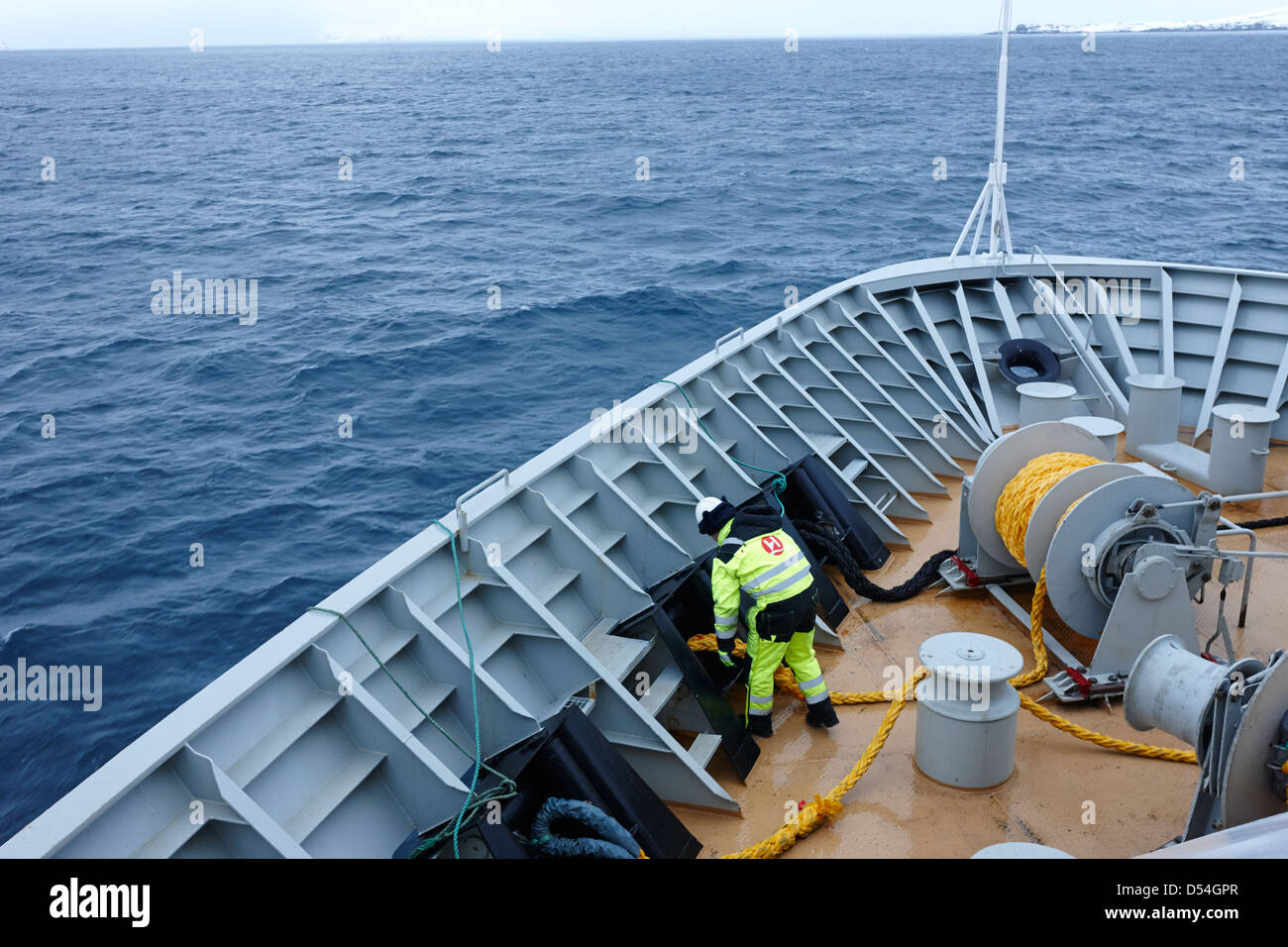 crewman working on ships ropes on board hurtigruten passenger ship ...
