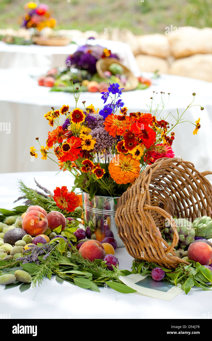 Farmers market bountiful centerpiece display on outdoor tables, basket ...