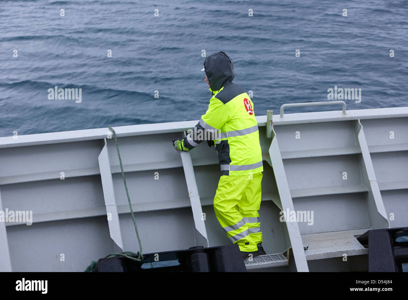 crewman working on ships ropes on board hurtigruten passenger ship ...