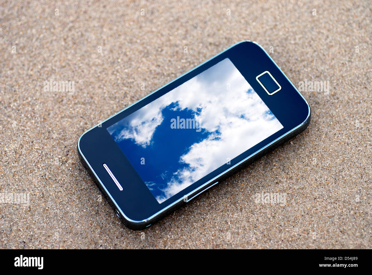 Close up of mobile phone on beach, with sky reflected Stock Photo - Alamy