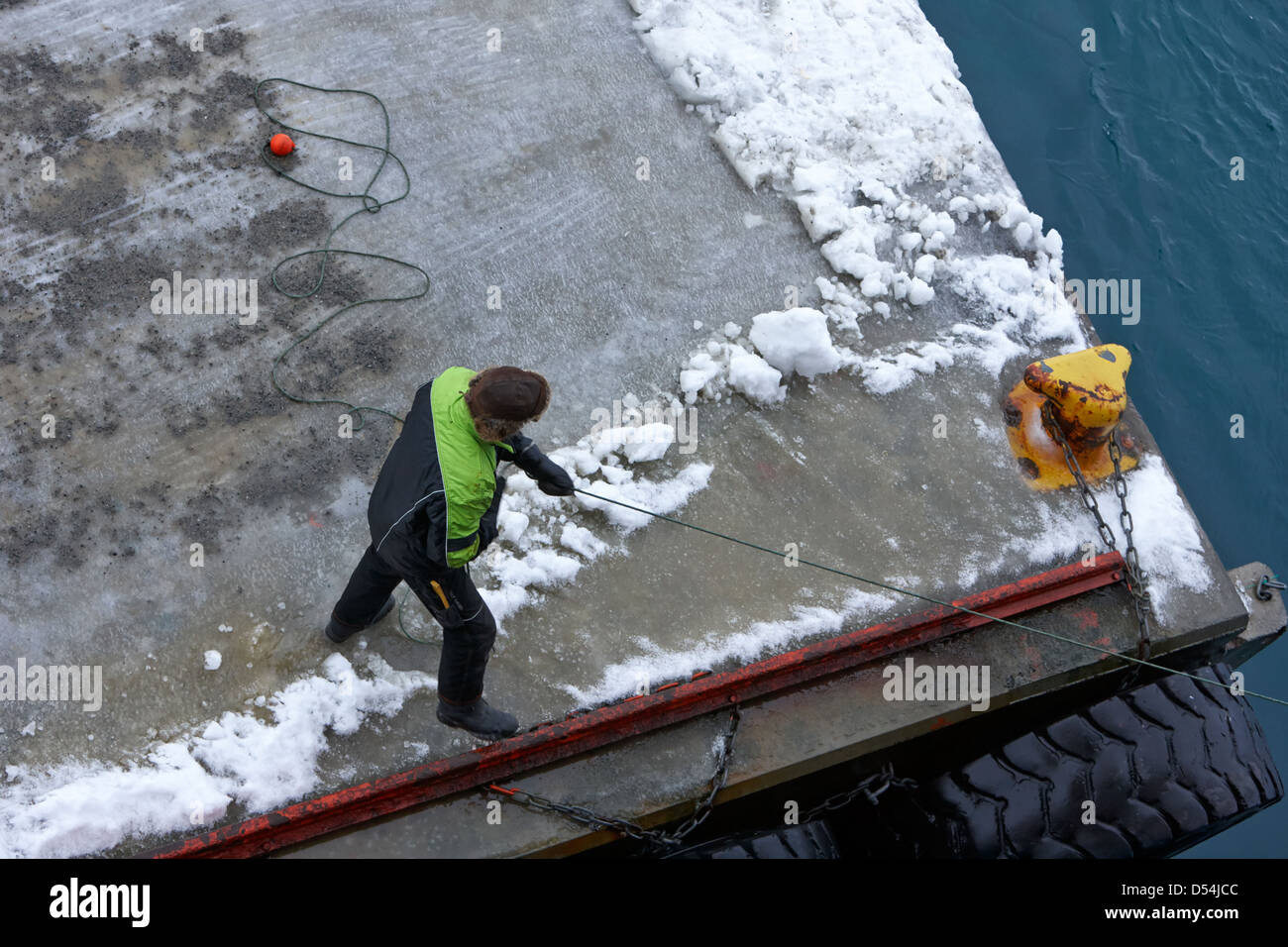 dock worker pulling on guide rope attached to ships ropes for ...