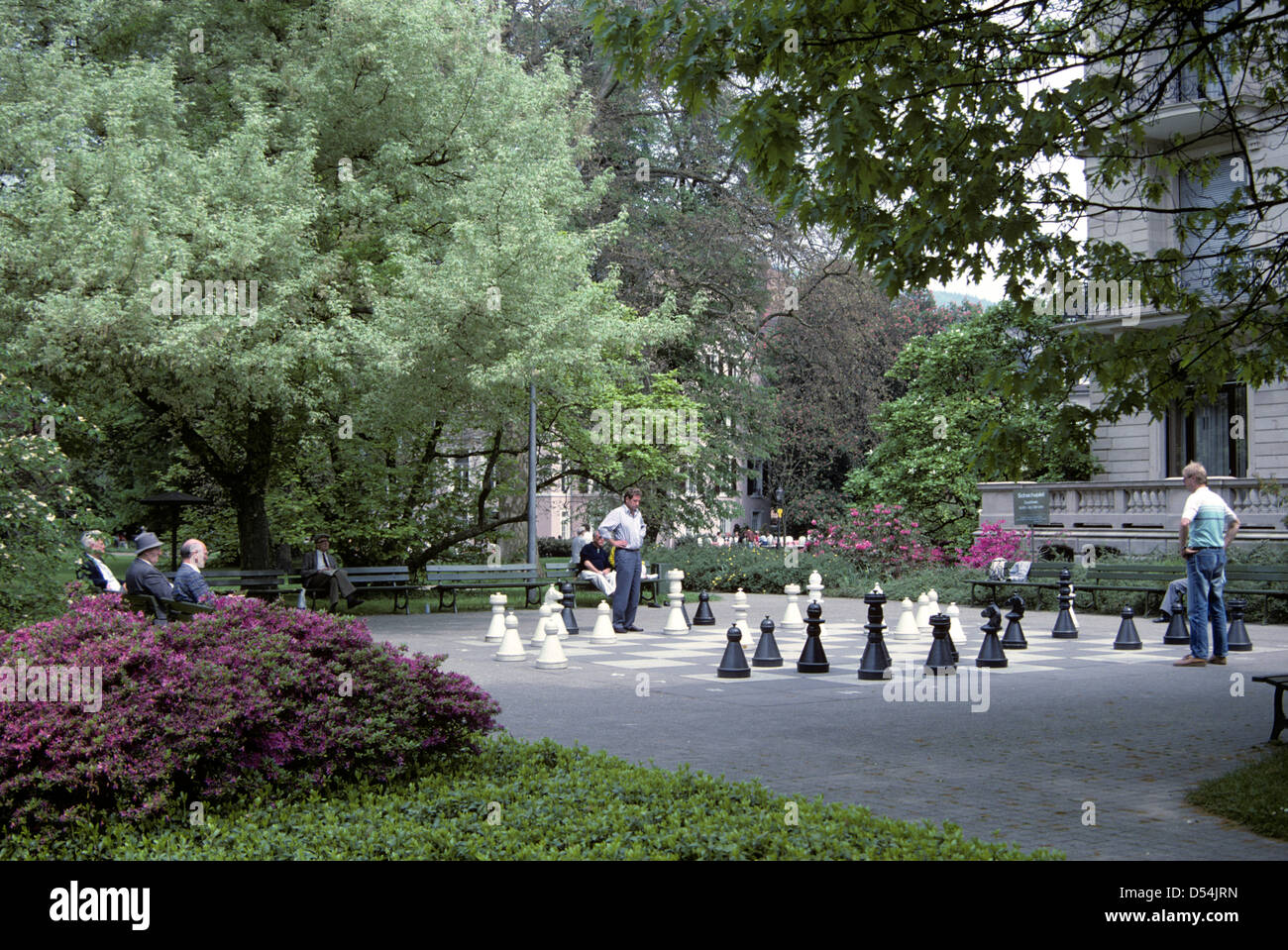 two men play chess on giant court in quiet park in Schlossgarten in the ...