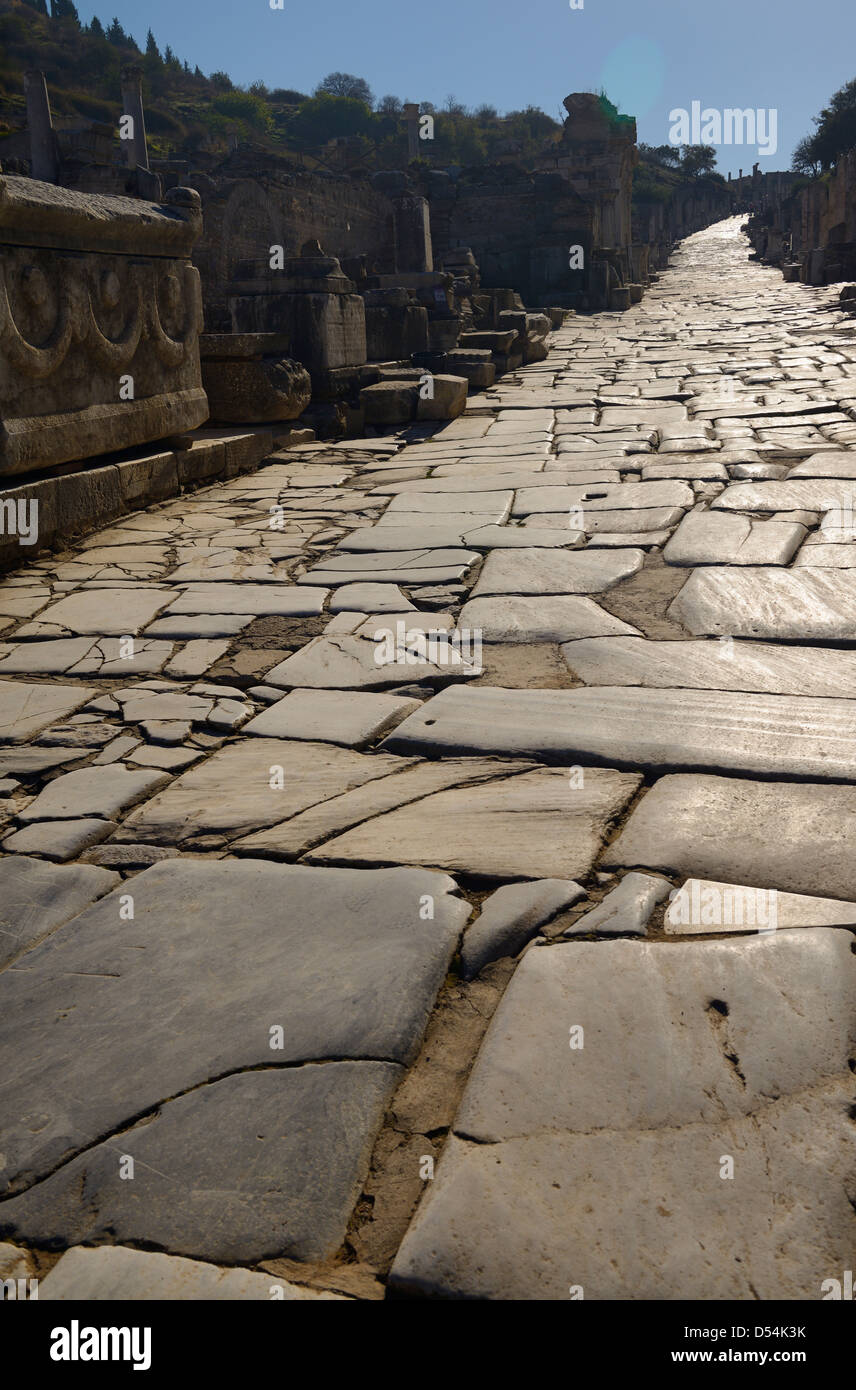 Worn stones of Curetes street in morning sun at ruins of ancient Roman ...