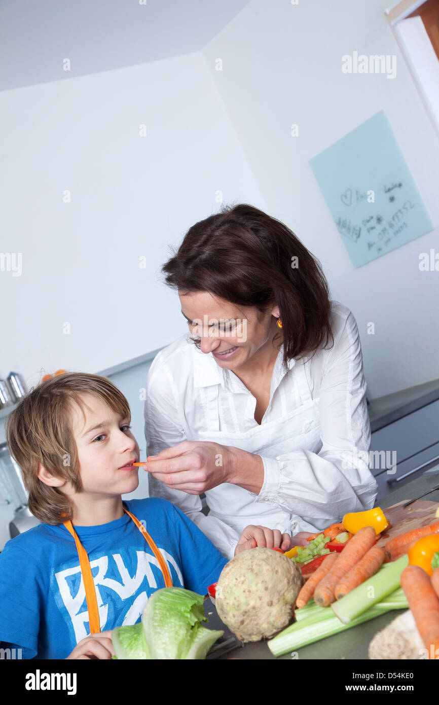 Basel, Switzerland, a woman with child when cooking in the kitchen ...