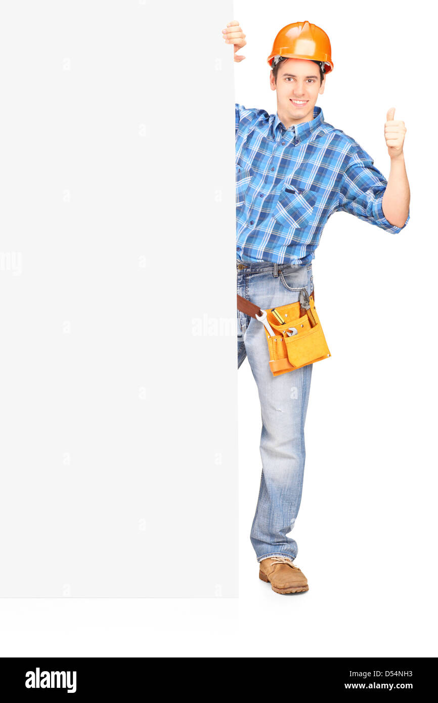 Full length portrait of a male worker with helmet posing behind a blank ...