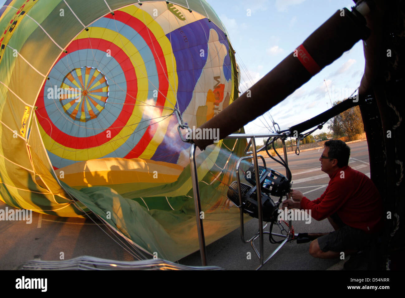 A crew member heats the air inside a hot air balloon envelope before a ...