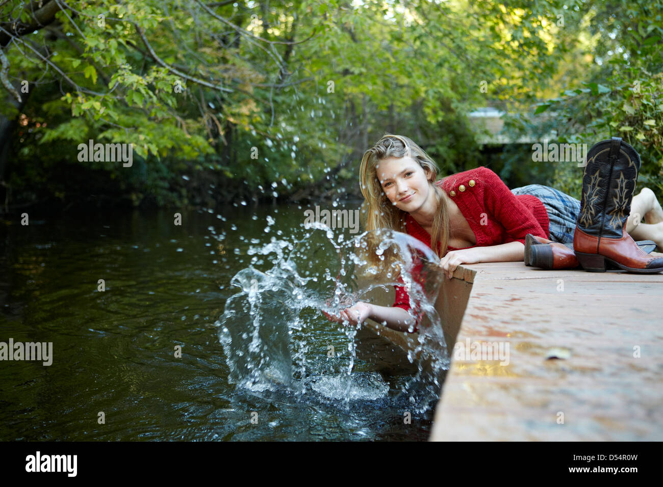 Teen splashing water on creek Stock Photo - Alamy