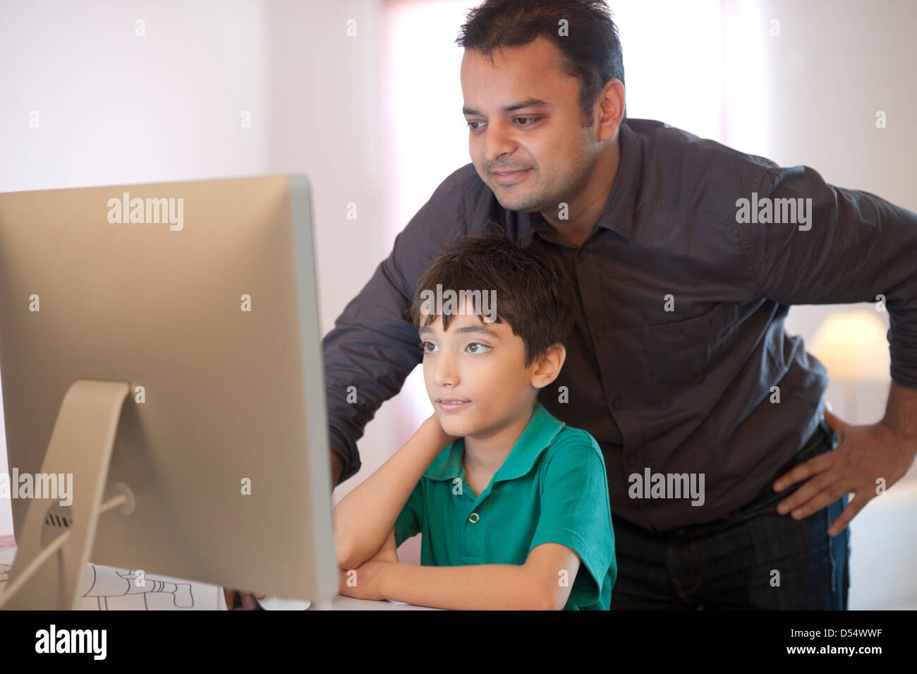 Boy using a desktop pc with her father Stock Photo - Alamy