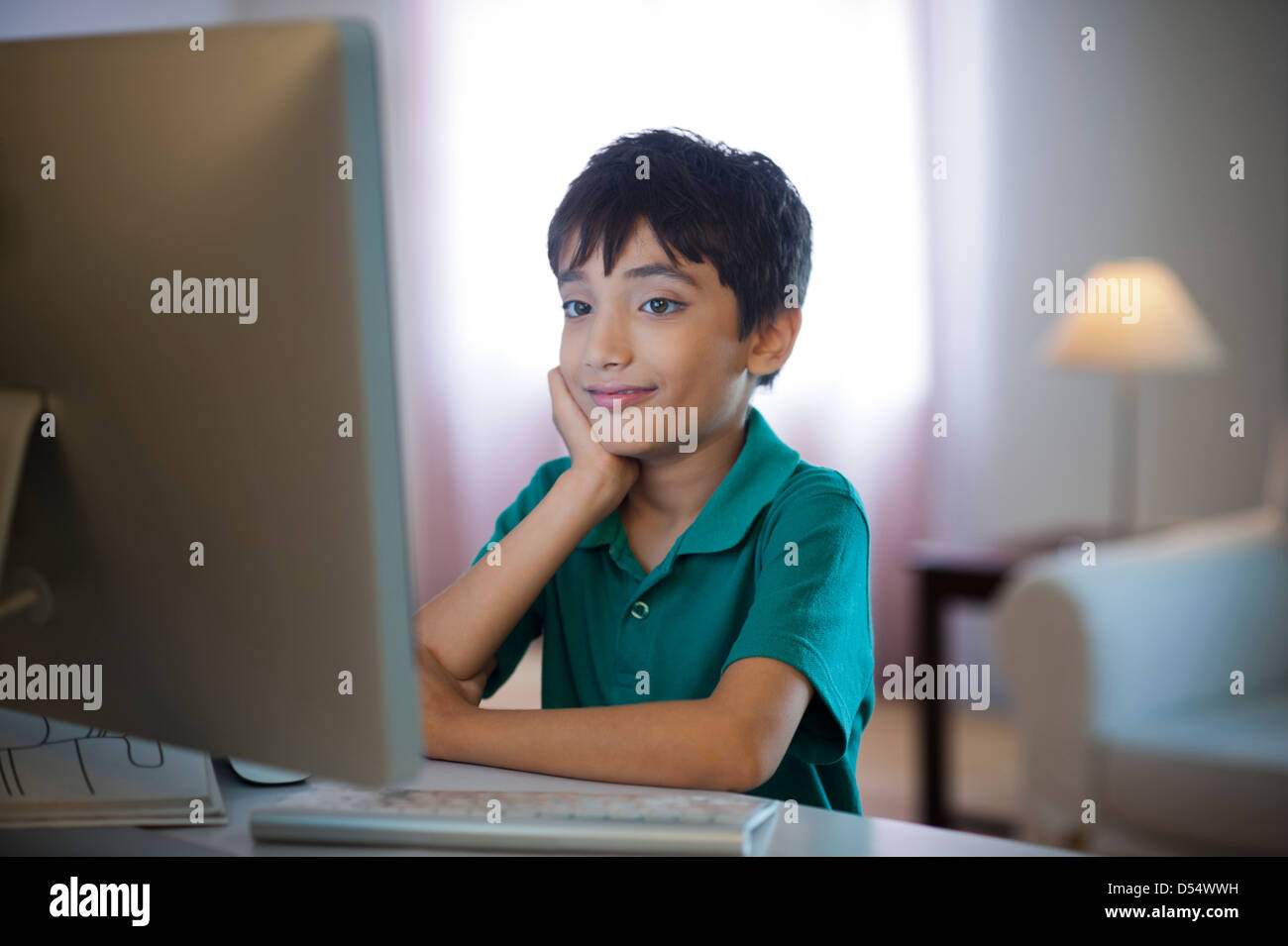 Boy looking at a desktop pc at study table Stock Photo - Alamy