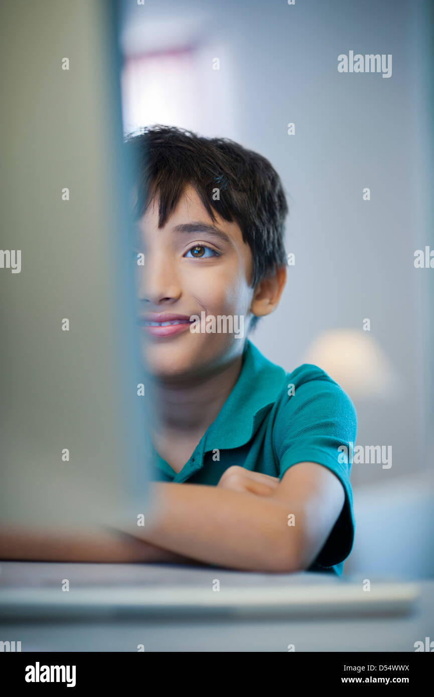 Boy looking at a desktop pc at study table Stock Photo - Alamy