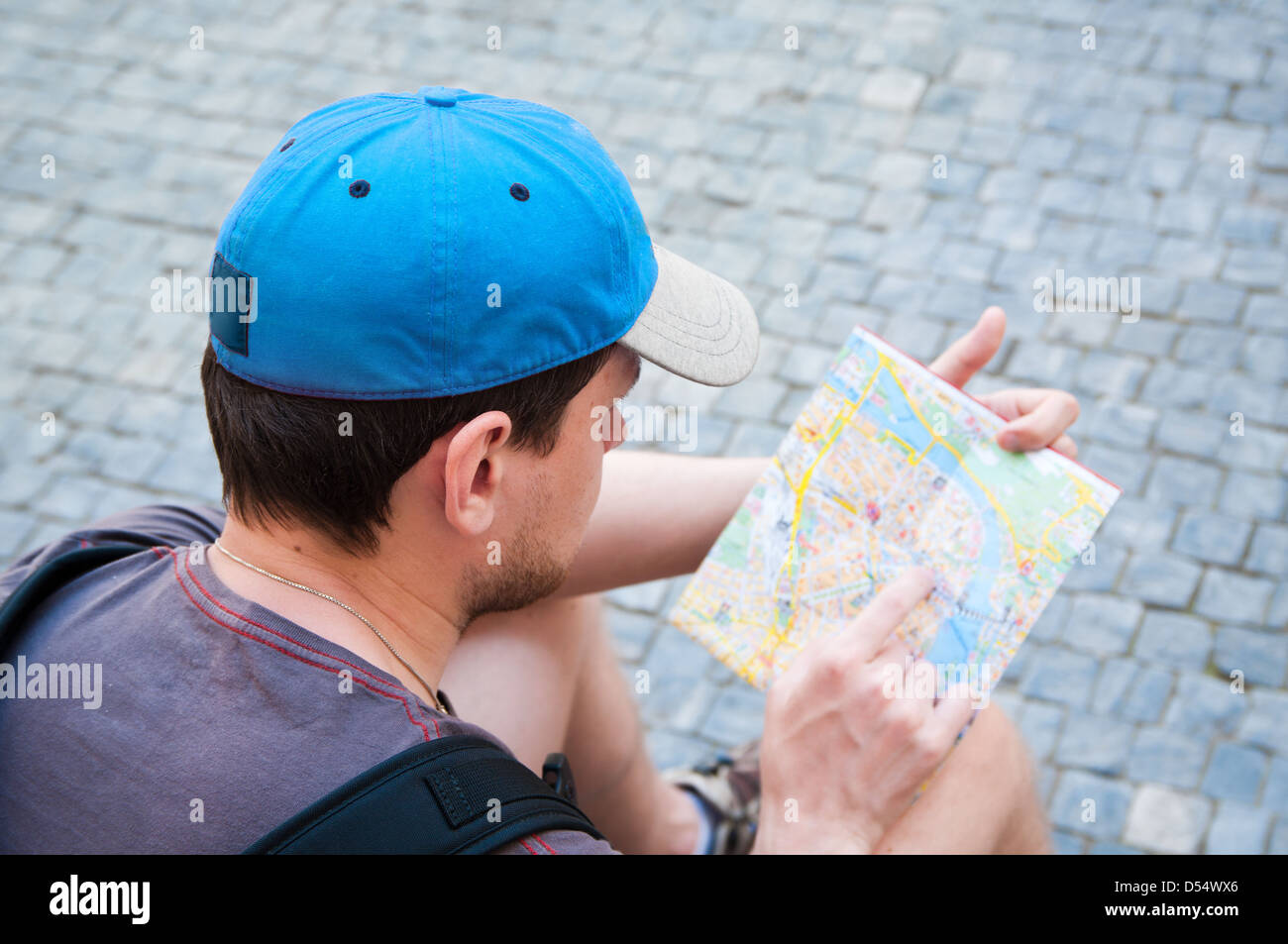 Tourist on the street looking at a guide Stock Photo - Alamy