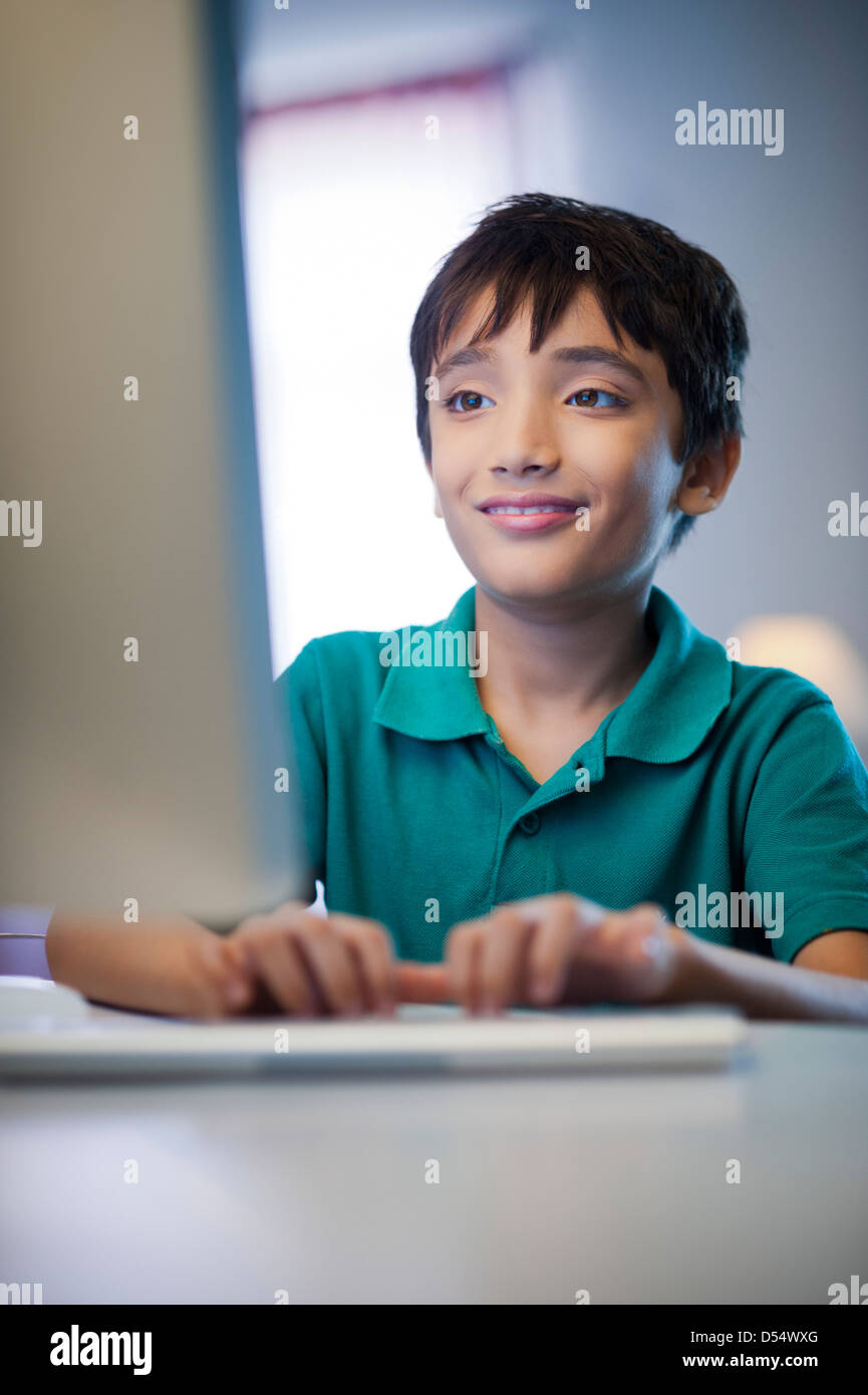 Boy using a desktop pc and smiling at home Stock Photo - Alamy