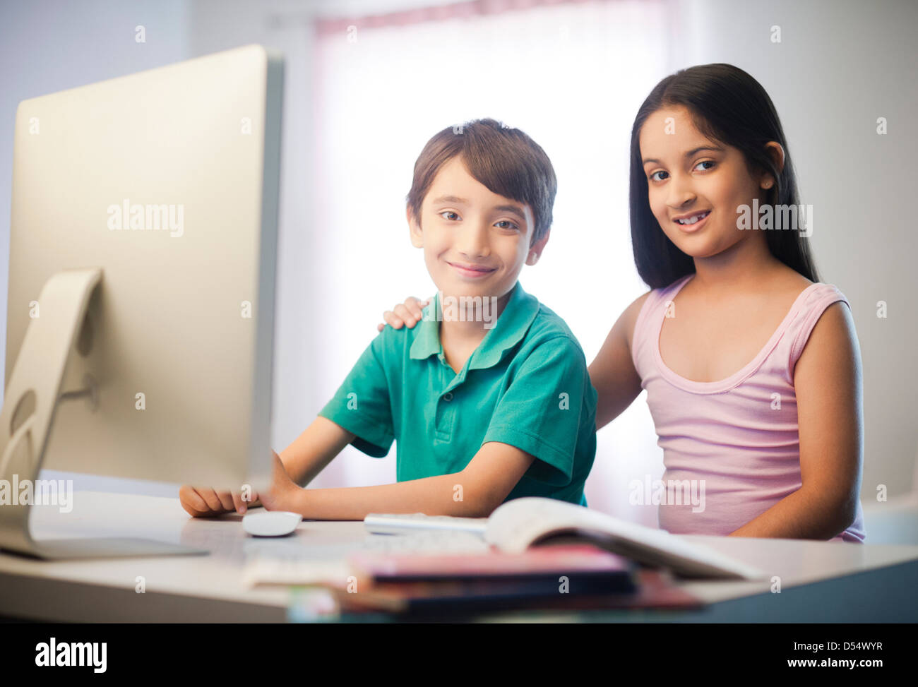 Portrait of two children smiling at a study table Stock Photo - Alamy
