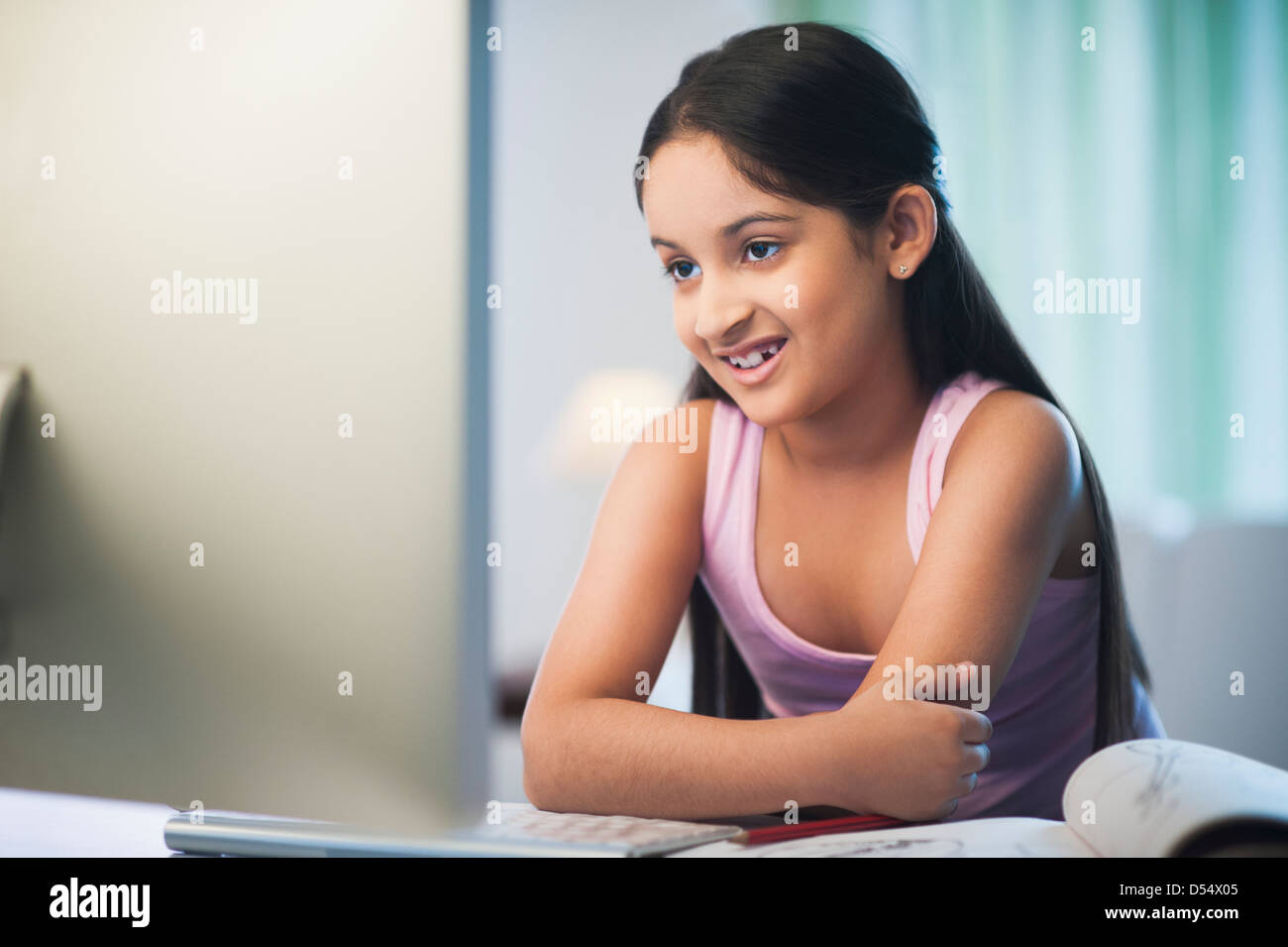 Girl looking at a desktop pc at study table Stock Photo - Alamy