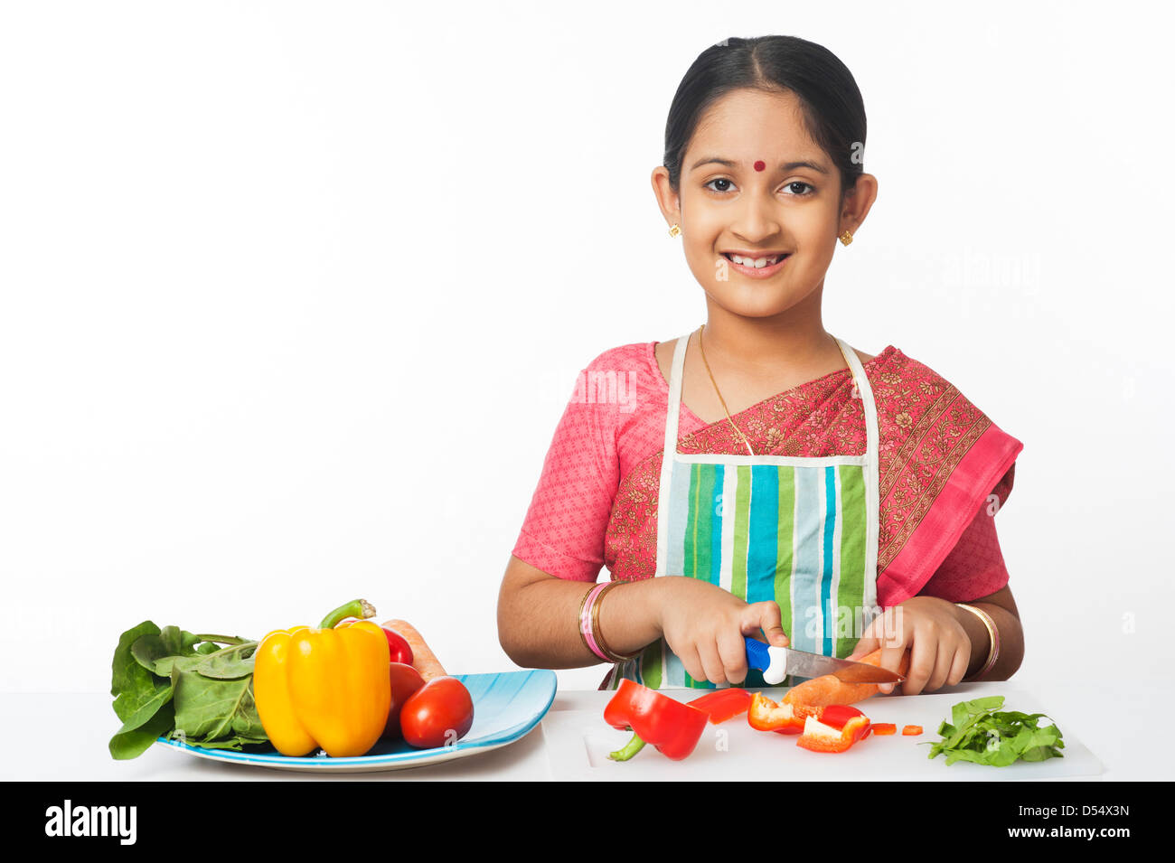 Girl imitating like woman cutting vegetables and smiling Stock Photo ...