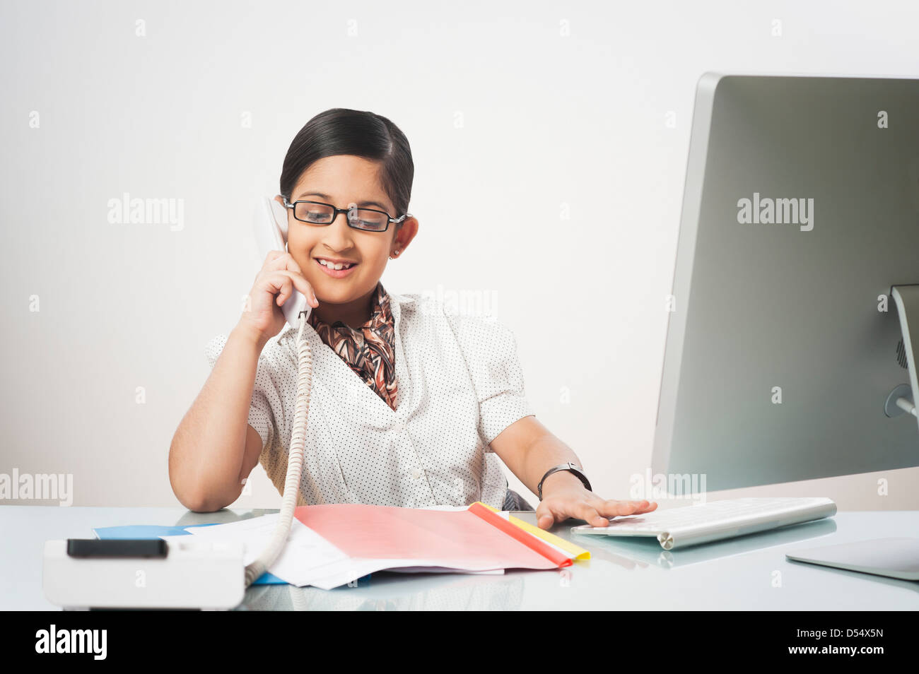 Girl imitating like businesswoman talking on a landline phone while ...