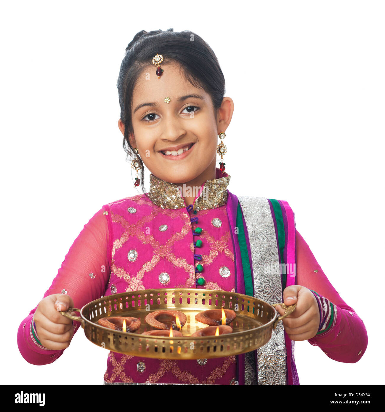 Girl imitating like woman holding oil lamps and smiling on diwali Stock ...