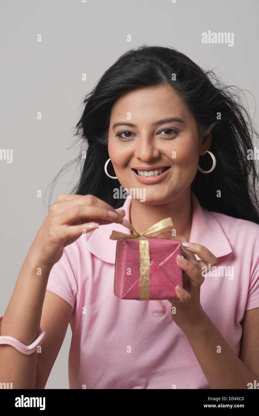 Portrait of a woman opening a gift box and smiling Stock Photo - Alamy