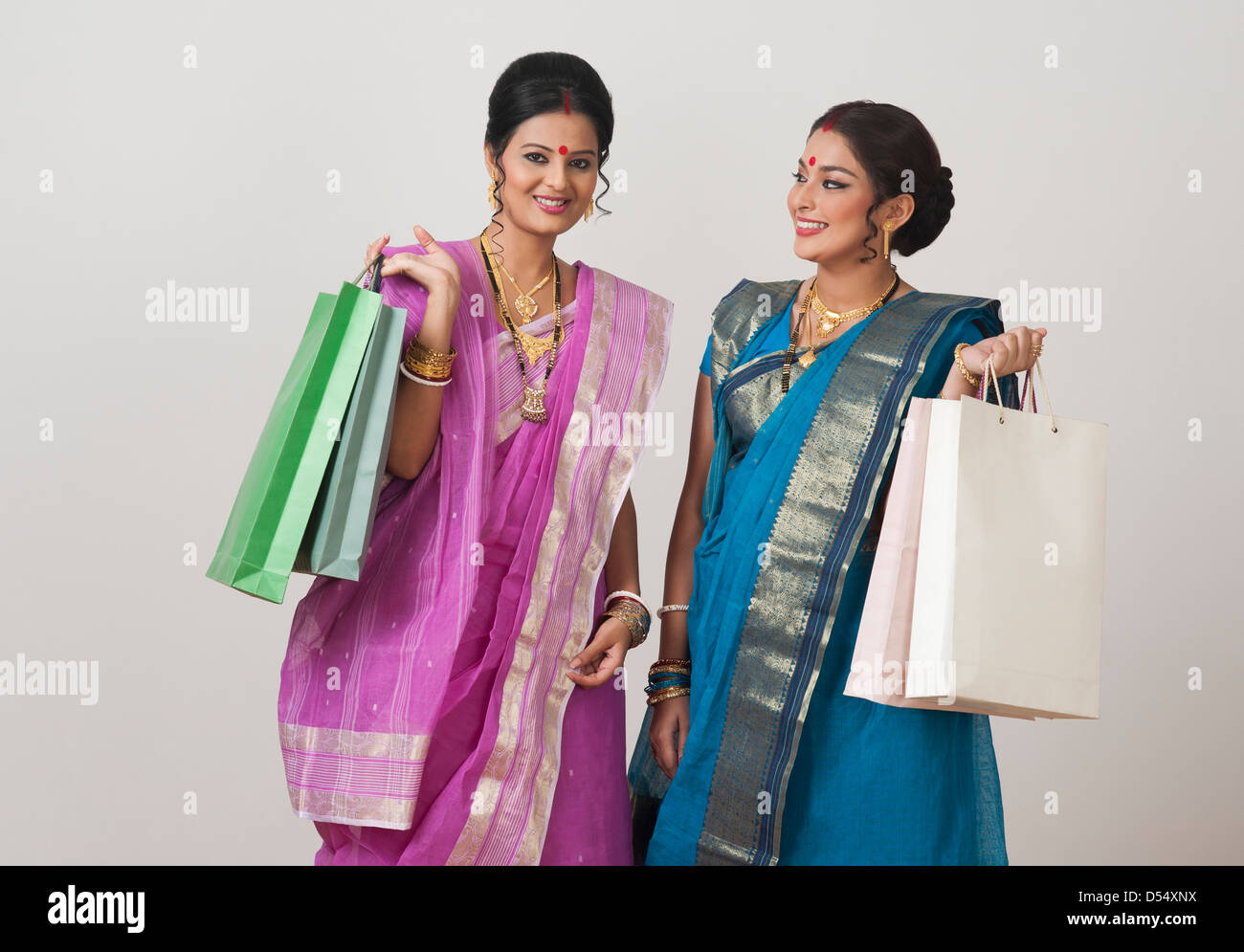 Two Bengali women carrying shopping bags and smiling Stock Photo - Alamy