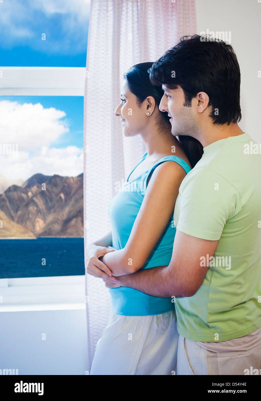 Romantic couple standing at window Stock Photo - Alamy