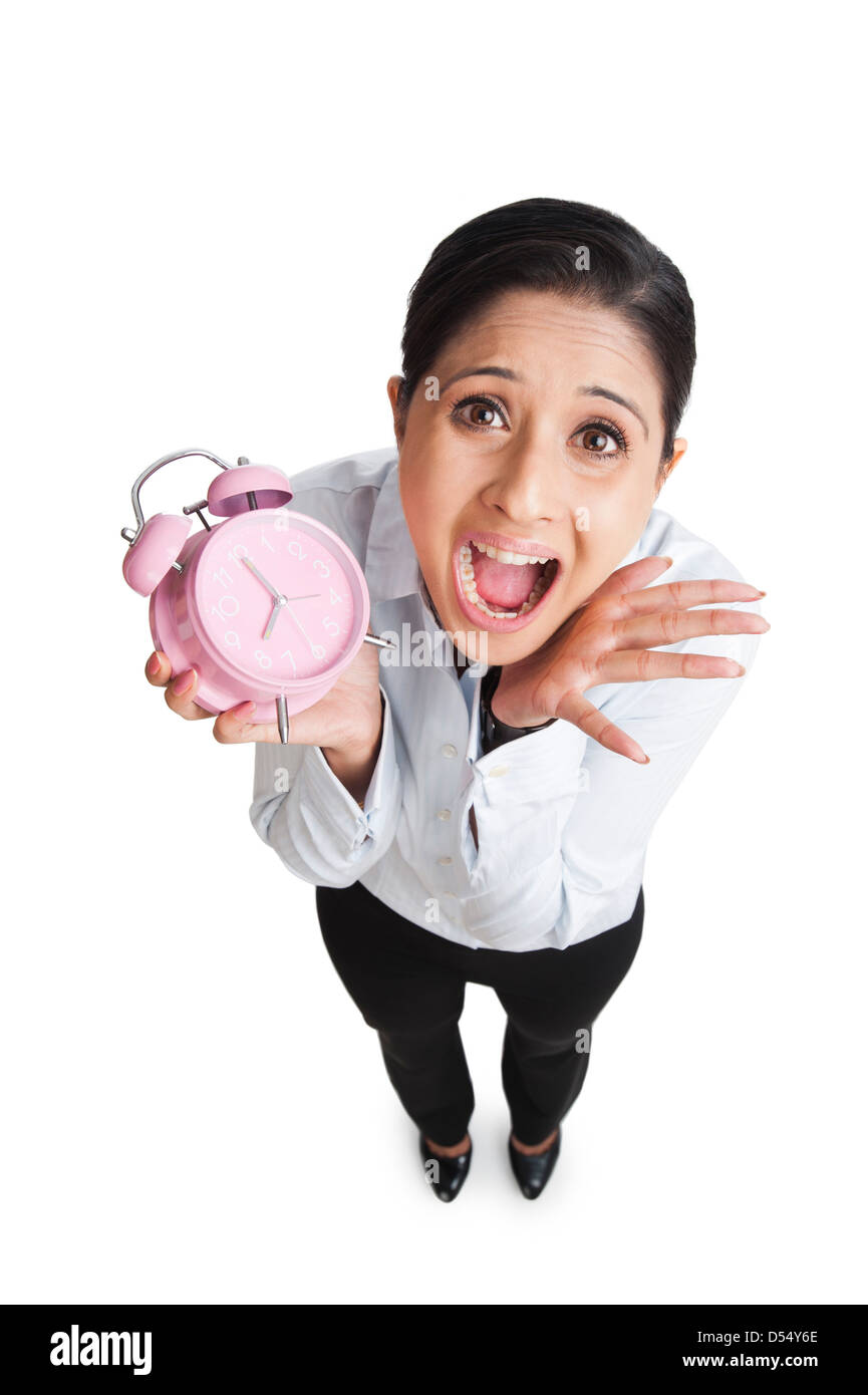 Businesswoman holding an alarm clock and screaming Stock Photo - Alamy