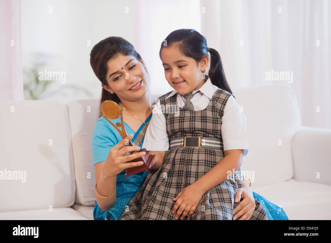 Woman and her daughter looking at a trophy Stock Photo - Alamy