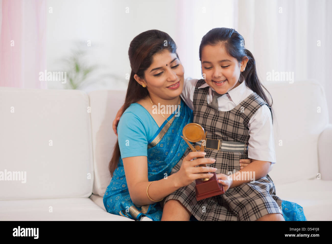 Woman and her daughter looking at a trophy Stock Photo - Alamy