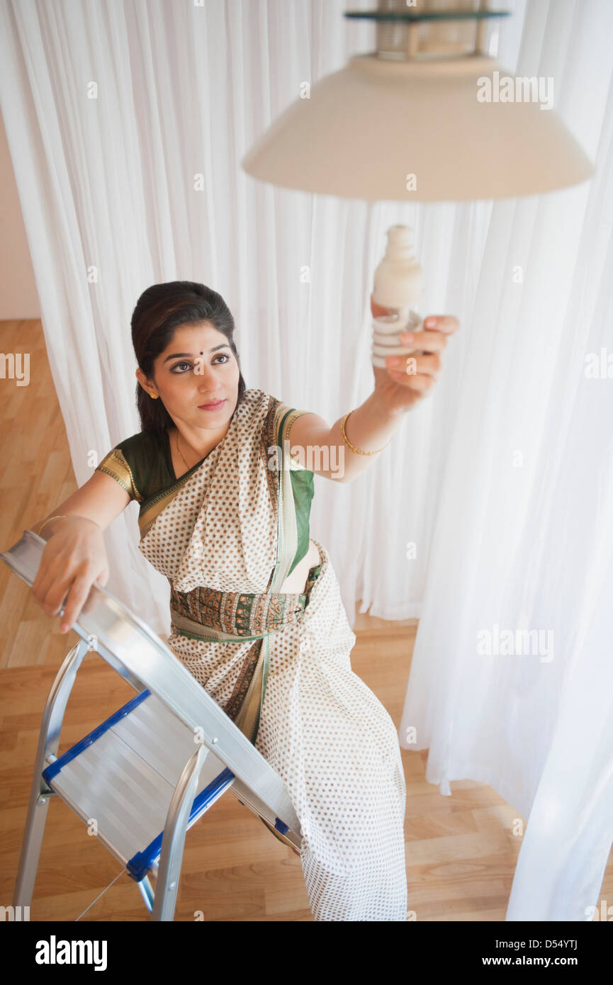Woman changing bulb of a lamp Stock Photo - Alamy