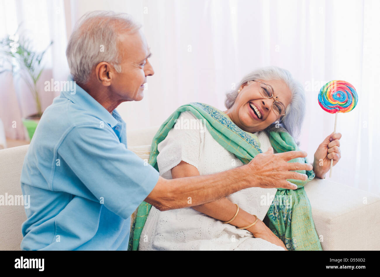 Man trying to grab a lollipop from his wife Stock Photo - Alamy