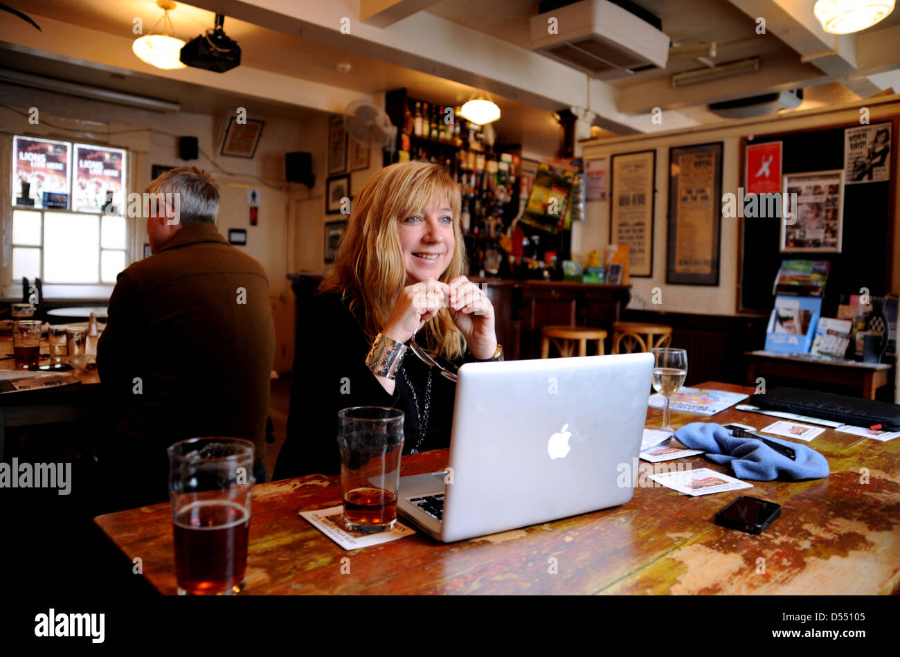 Woman at work on an Apple Macbook Pro laptop computer in a pub Stock ...