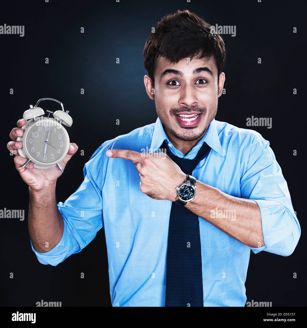 Businessman showing an alarm clock Stock Photo - Alamy