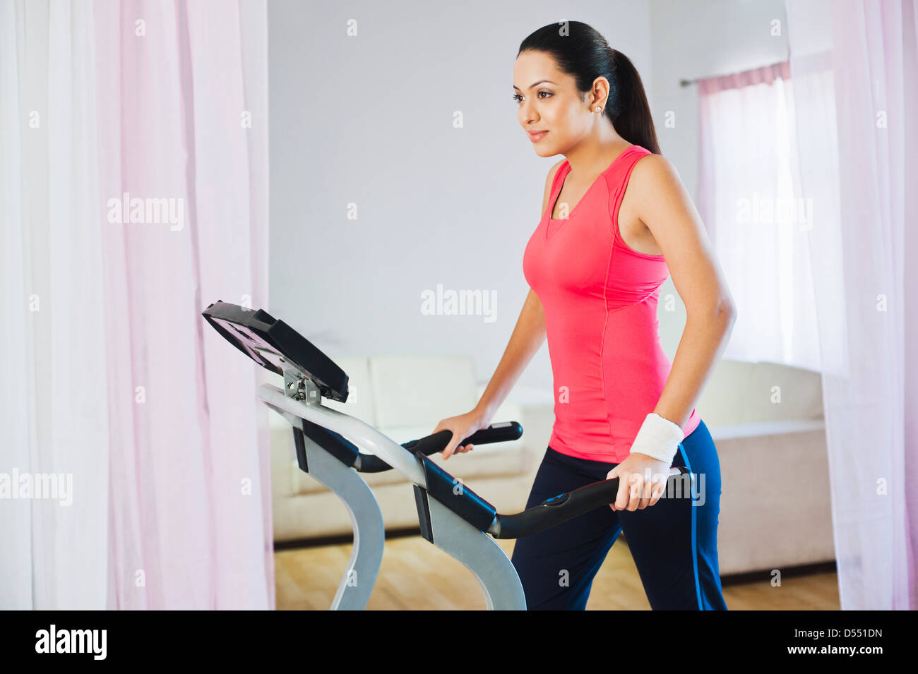 Woman running on a treadmill Stock Photo - Alamy