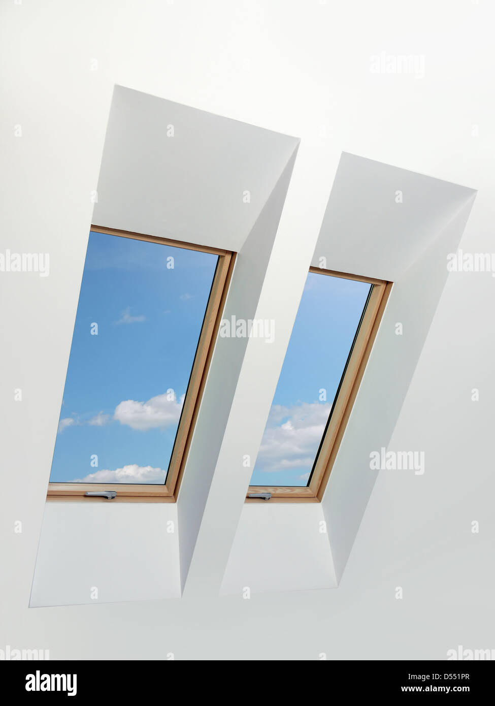 Two attic windows with blue sky view Stock Photo - Alamy