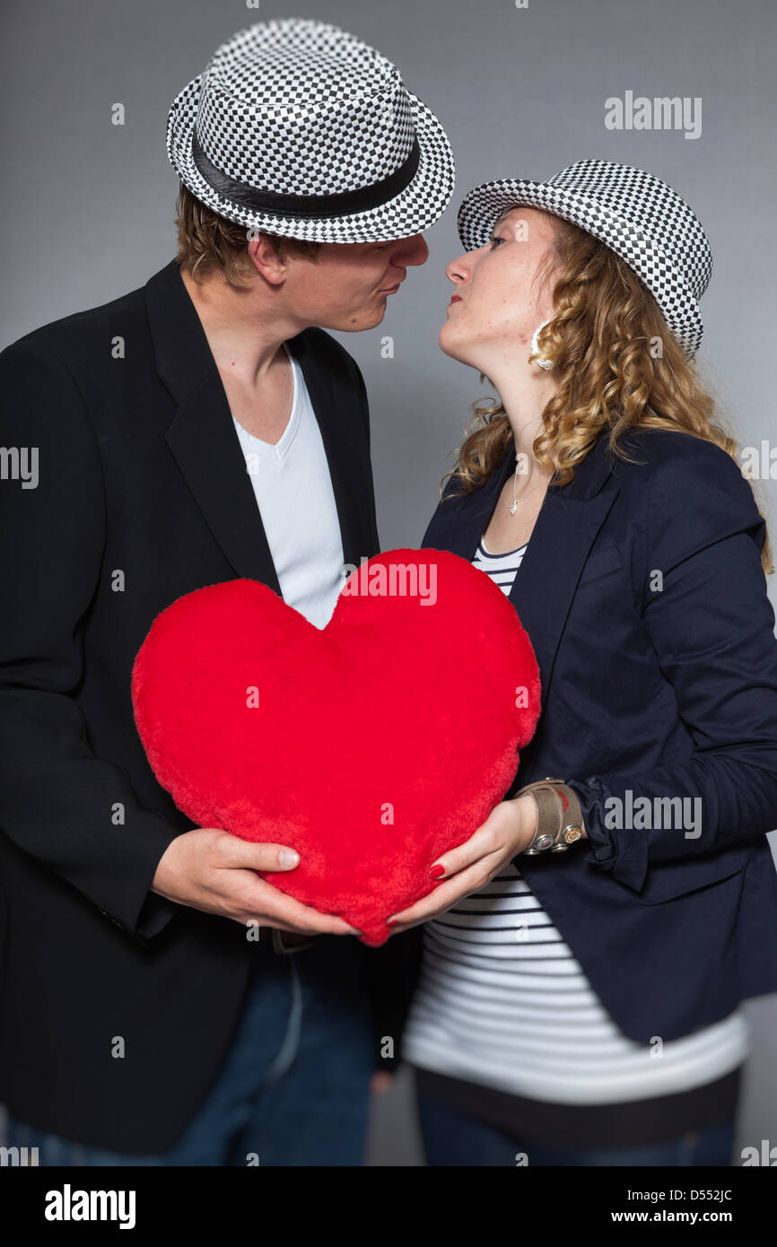 Young couple in love holding big red heart. Man and woman Stock Photo ...