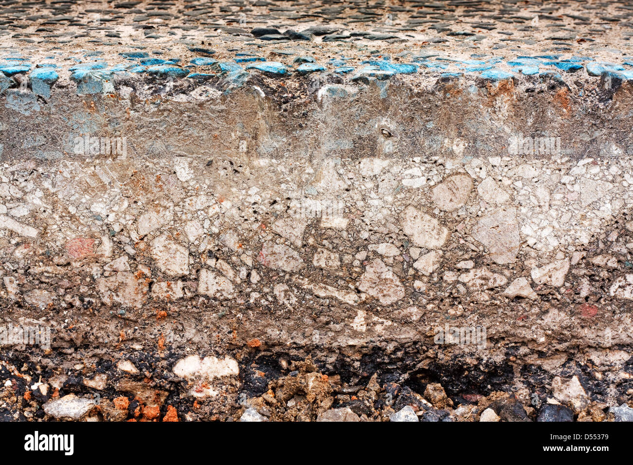 Sliced cross section of a street with exposed gravel underneath while ...