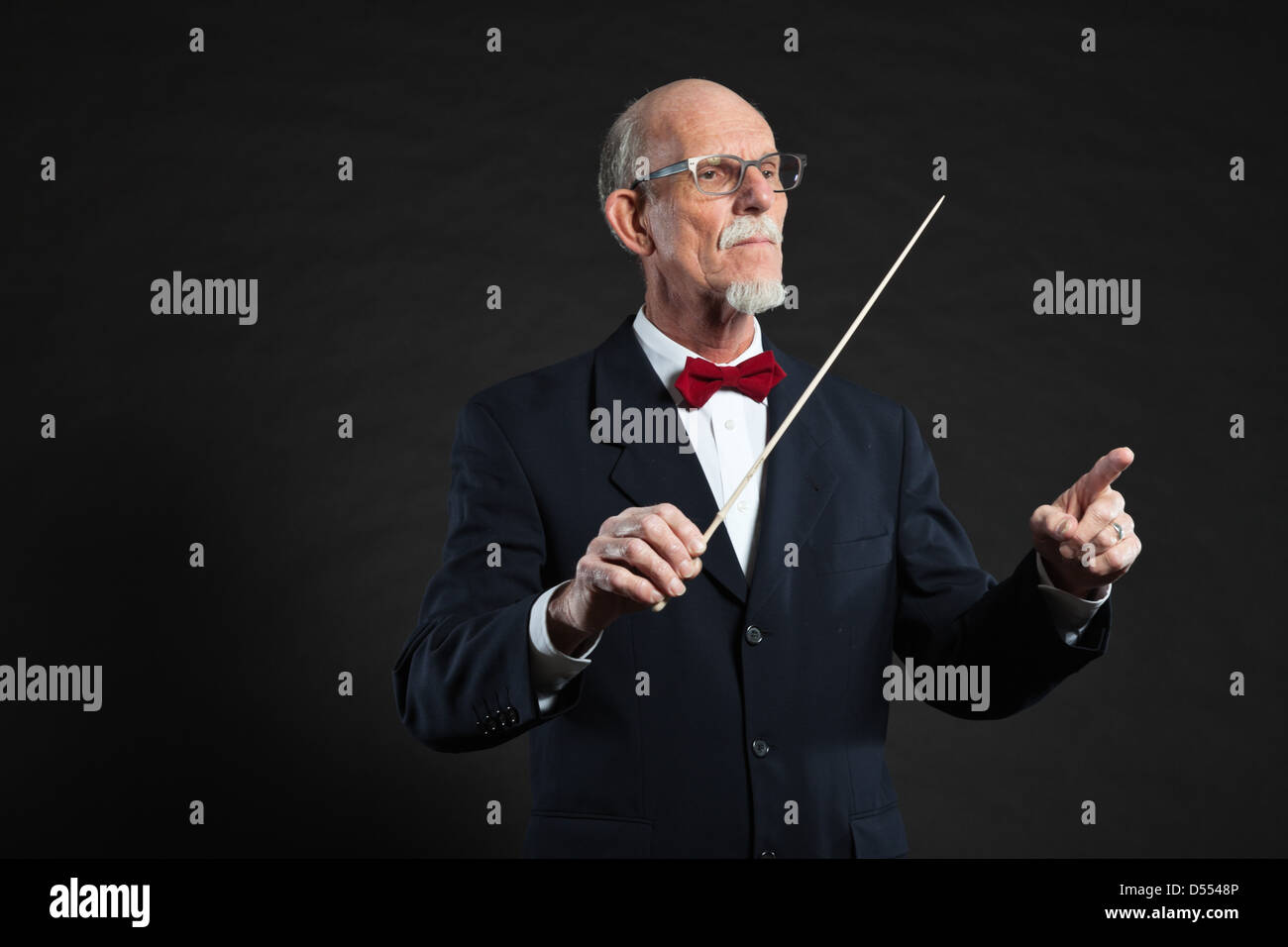 Senior conductor wearing suit. Studio shot Stock Photo - Alamy