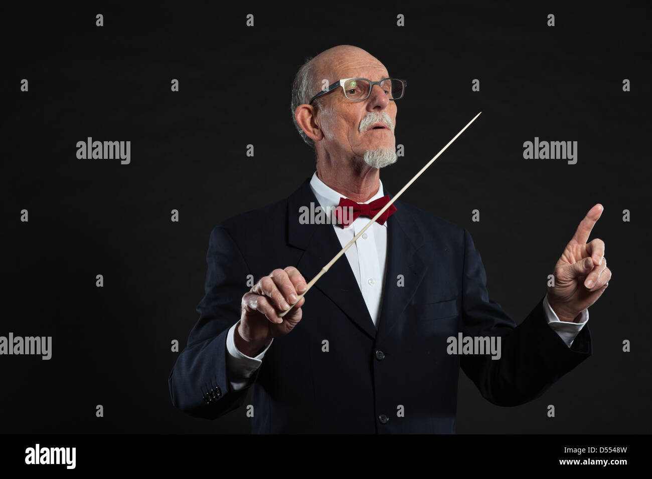 Senior conductor wearing suit. Studio shot Stock Photo - Alamy