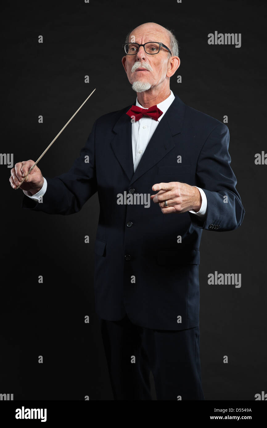 Senior conductor wearing suit. Studio shot Stock Photo - Alamy