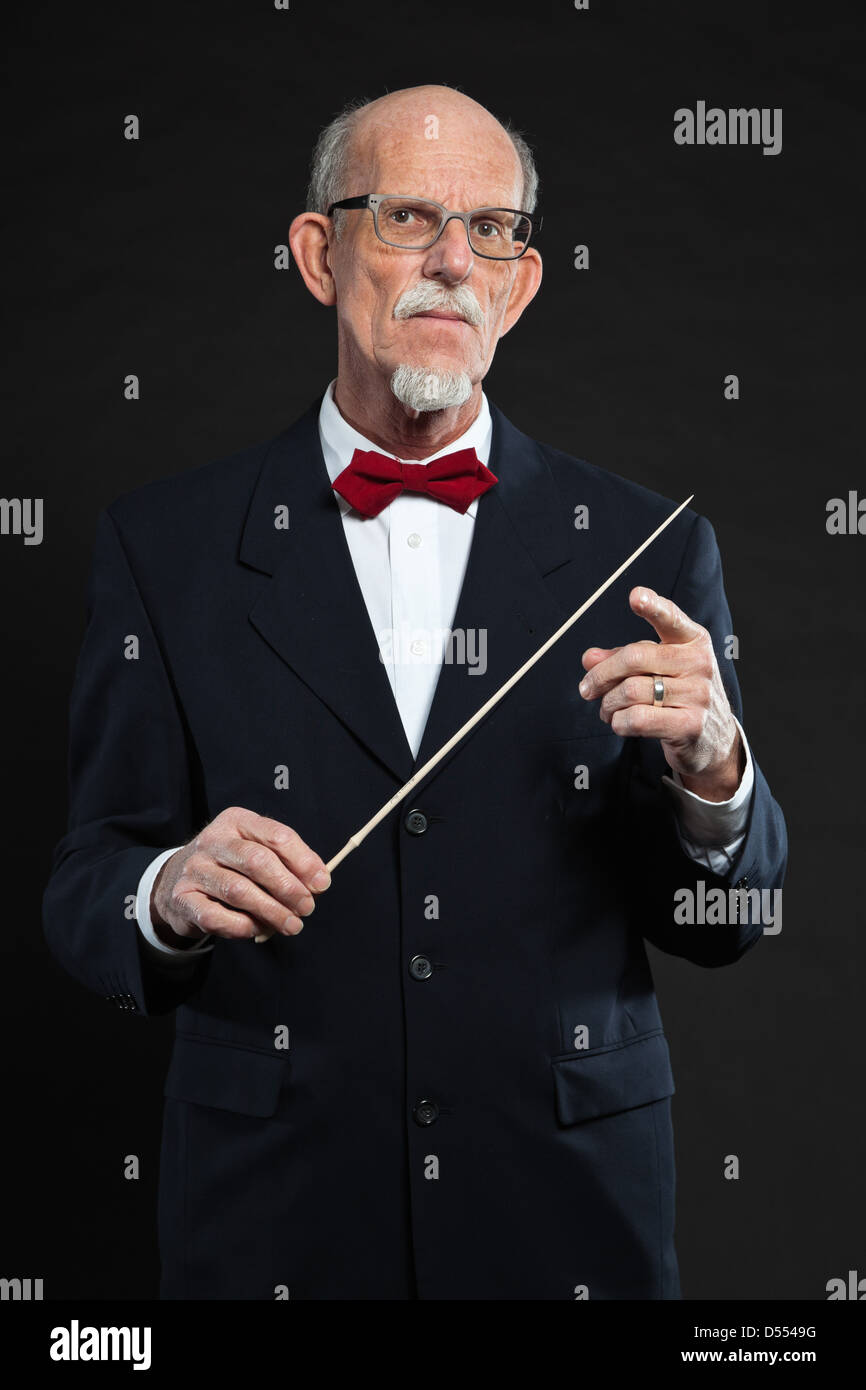 Senior conductor wearing suit. Studio shot Stock Photo - Alamy