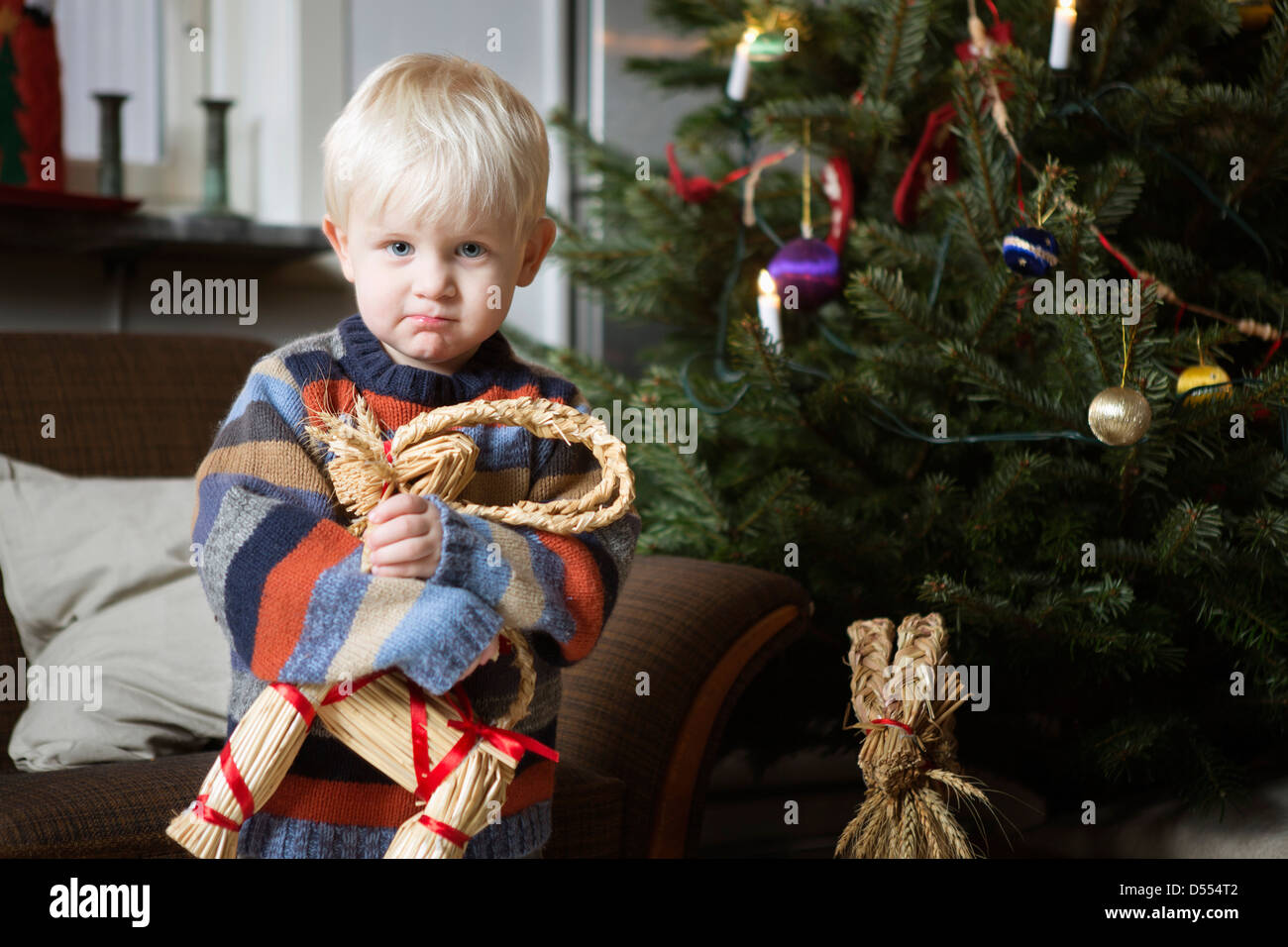 Boy holding toy by Christmas tree Stock Photo - Alamy