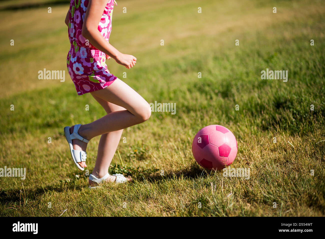 Girl playing soccer in field Stock Photo - Alamy