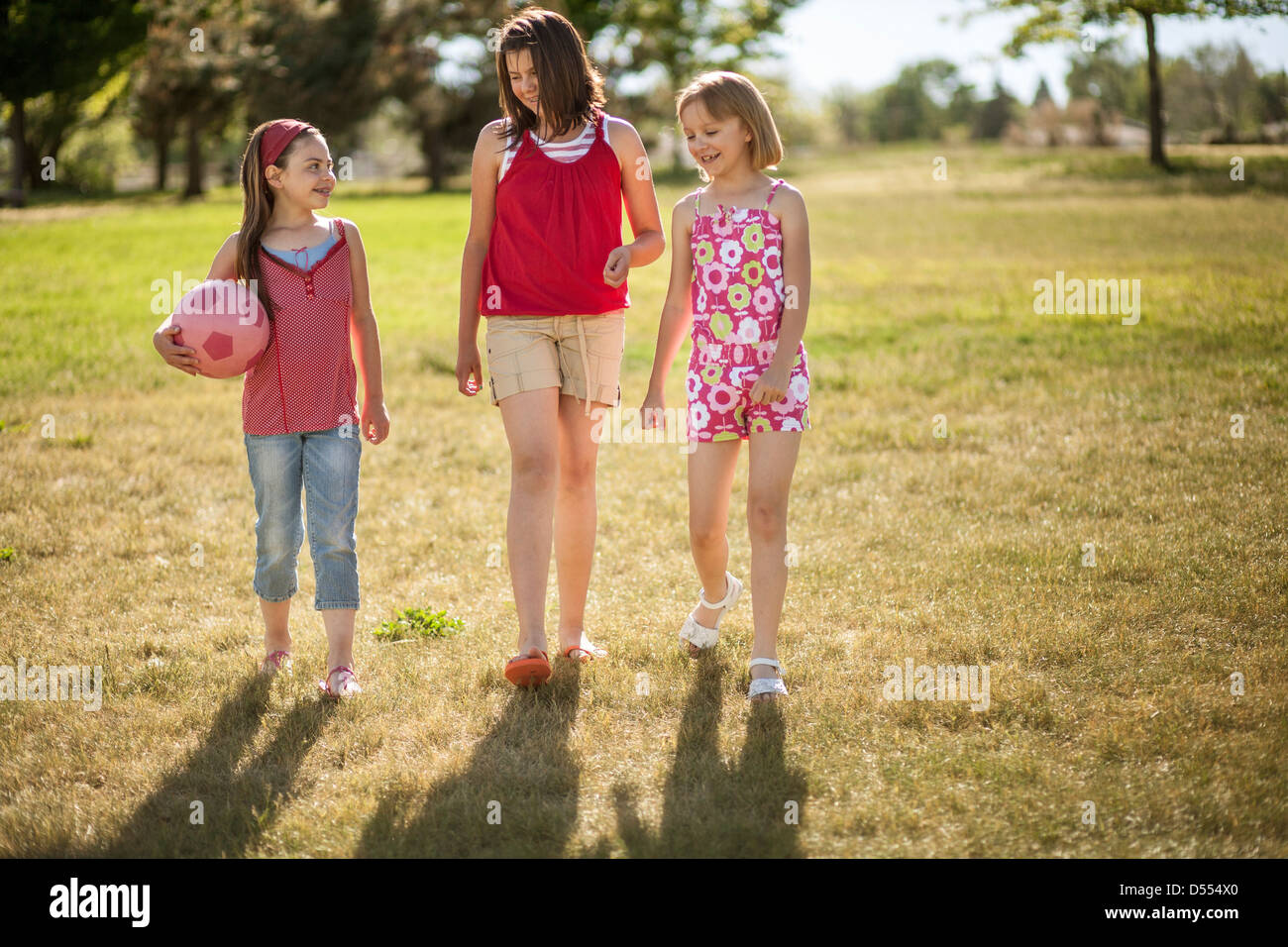 Girls walking together in field Stock Photo - Alamy
