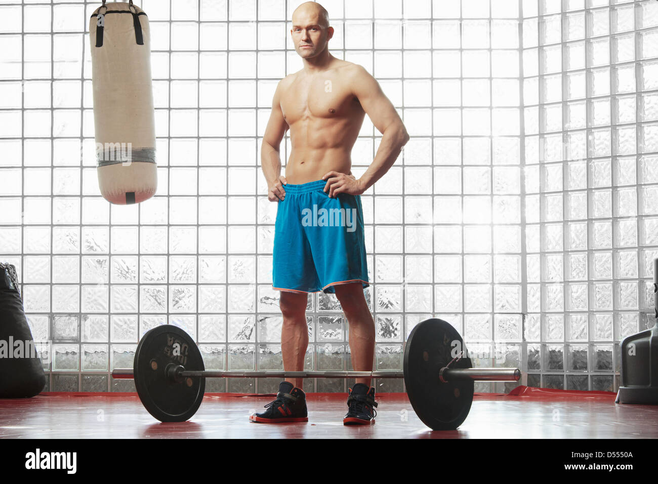 Man standing with weights in gym Stock Photo - Alamy