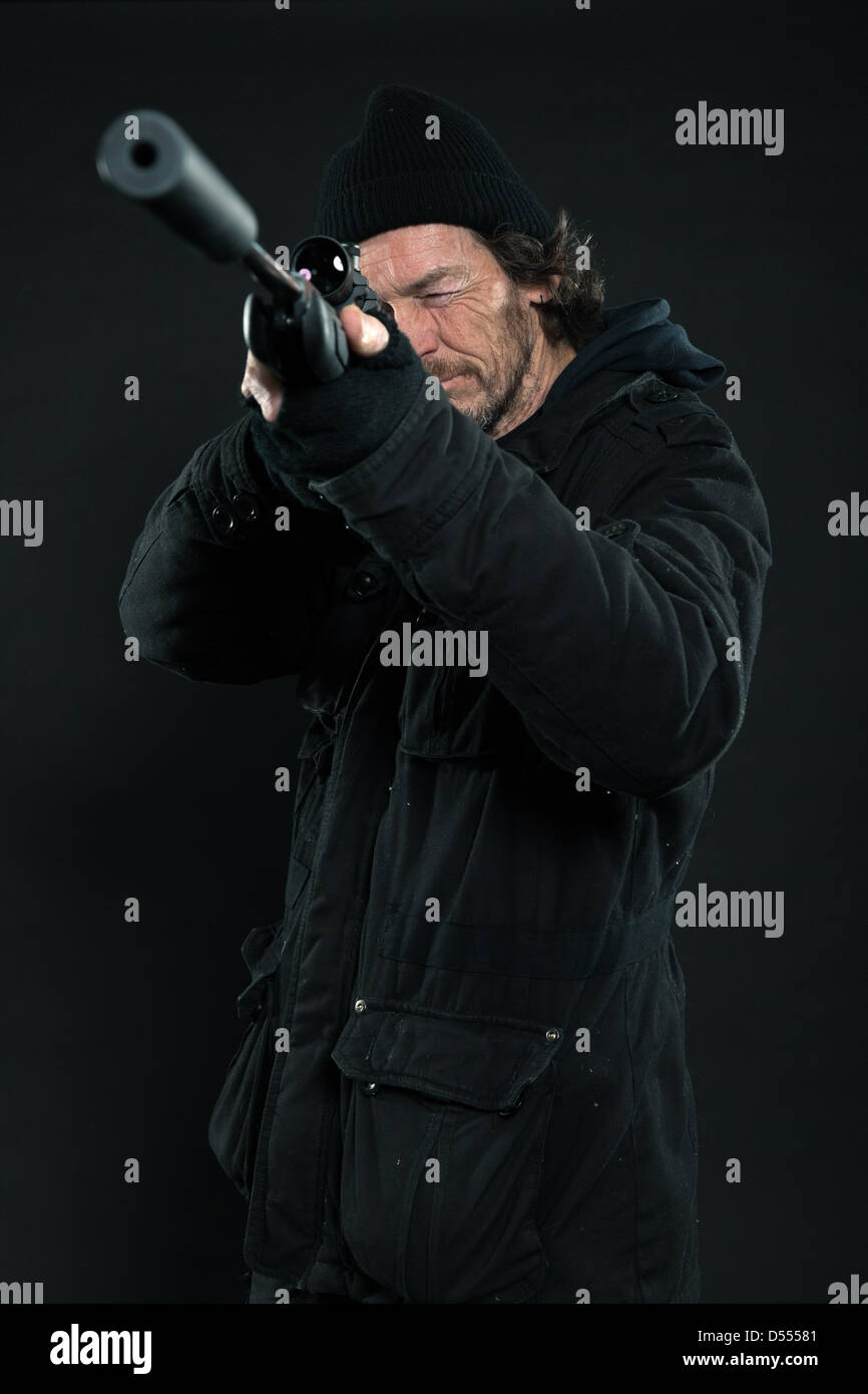 Sniper with beard in black holding gun. Studio shot Stock Photo - Alamy