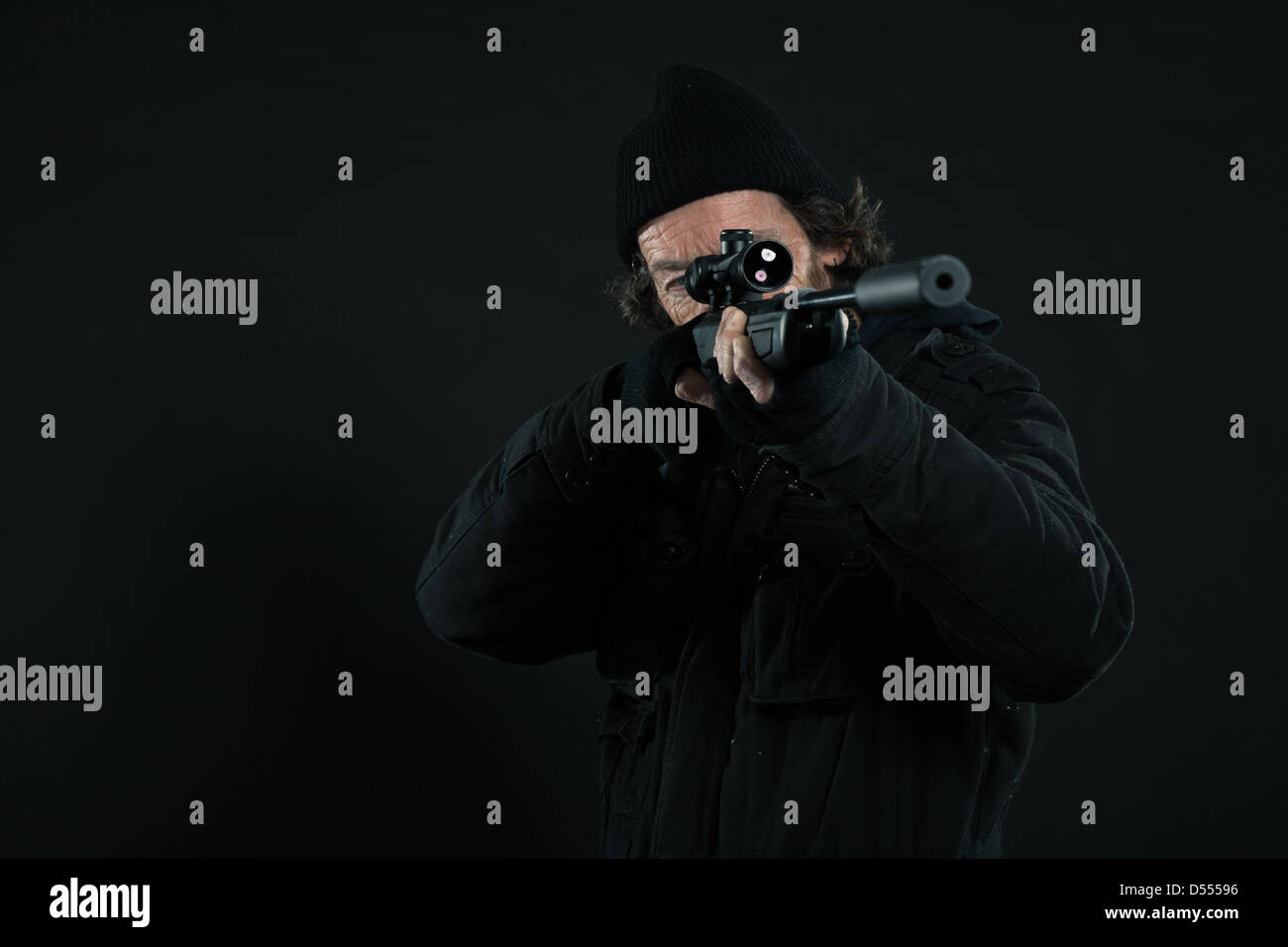 Sniper with beard in black holding gun. Studio shot Stock Photo - Alamy
