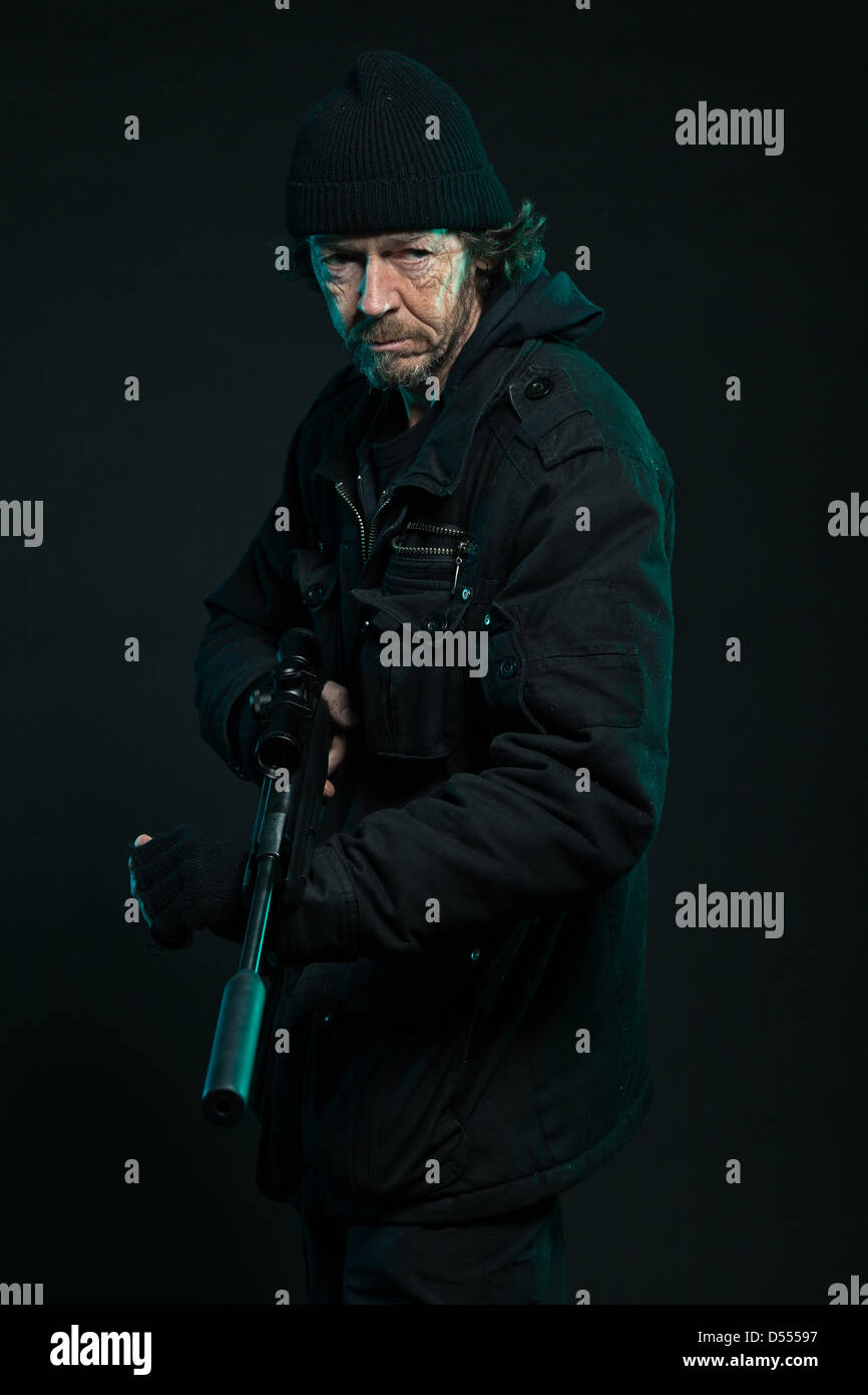 Sniper with beard in black holding gun. Studio shot Stock Photo - Alamy