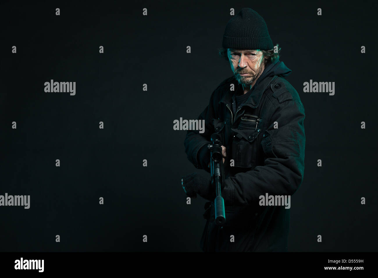 Sniper with beard in black holding gun. Studio shot Stock Photo - Alamy
